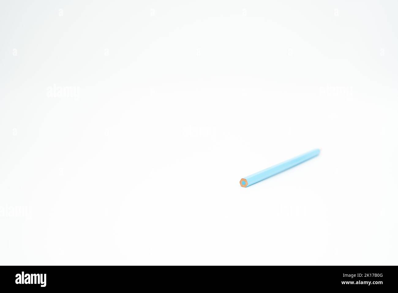 Blue wooden colored pencil on a white background with end part in focus ...