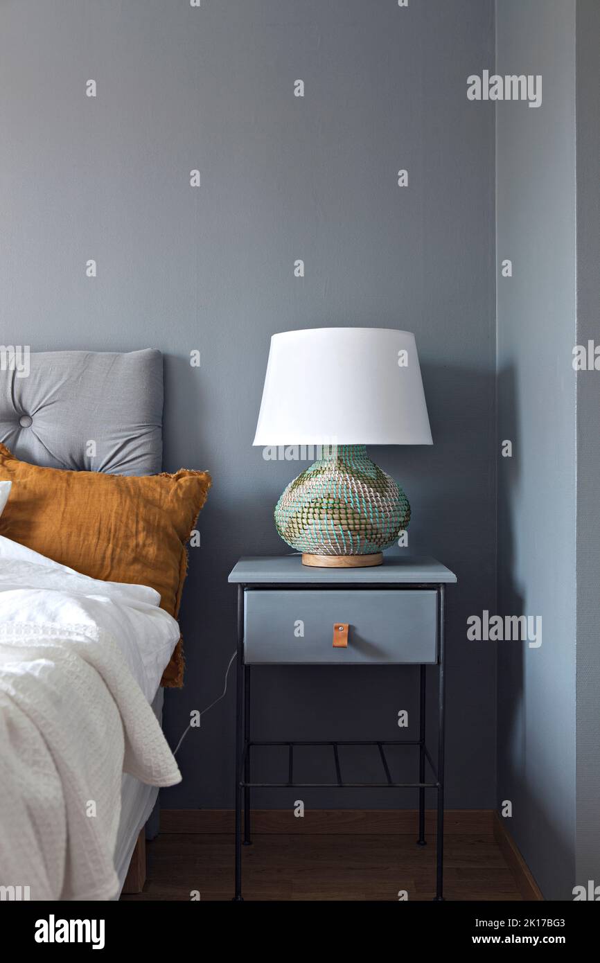 Lamp on night stand in bedroom Stock Photo - Alamy