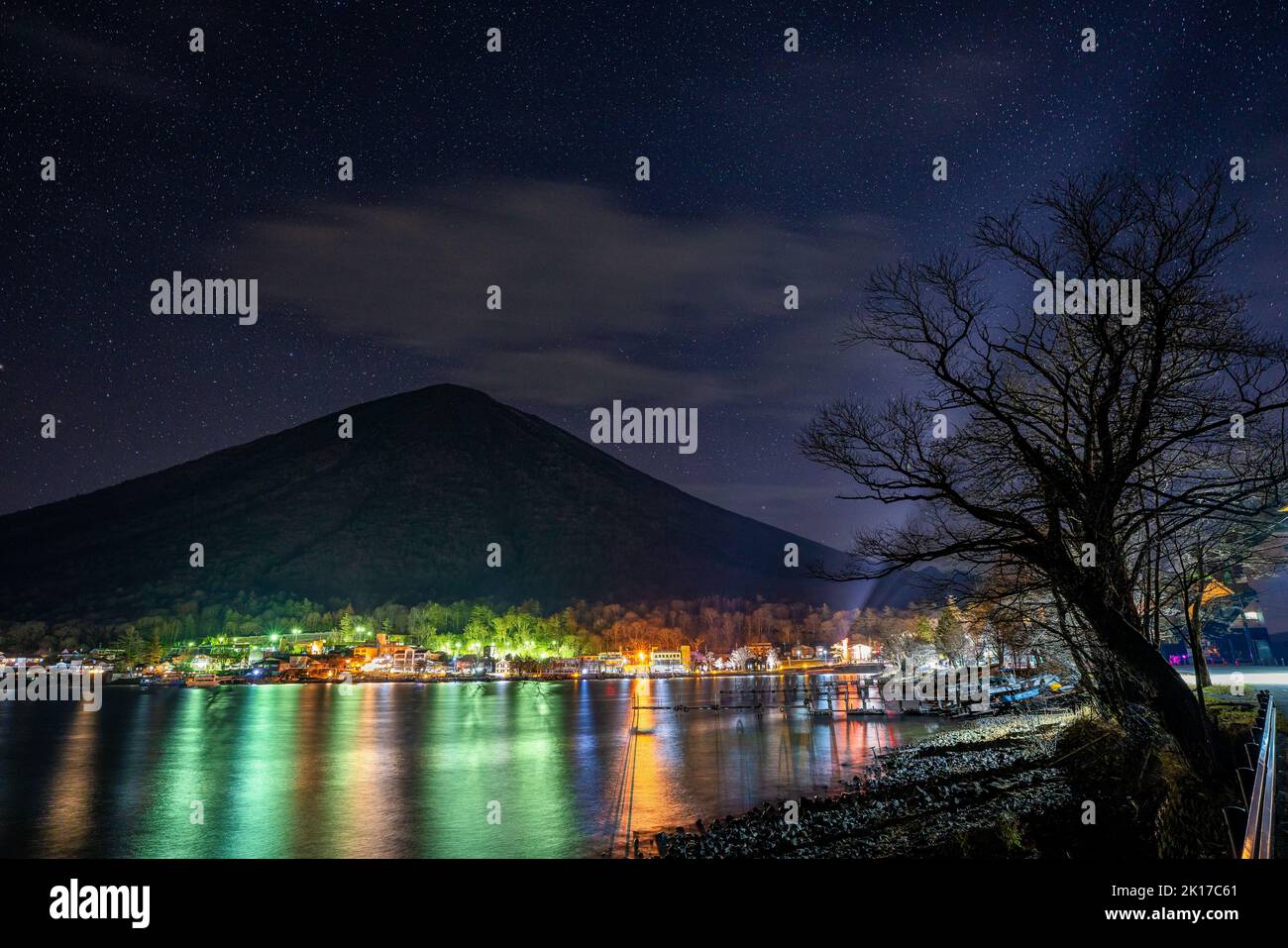 A scenic view of mount Nantai and coastline buildings with illuminated ...