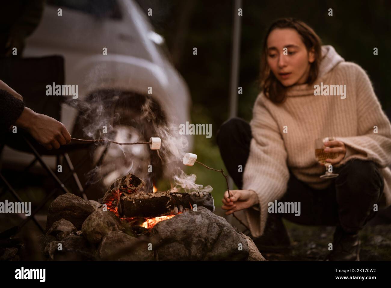 Woman roasting marshmallow over campfire Stock Photo - Alamy