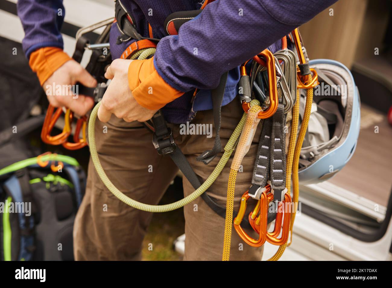 Rock climber putting gear on Stock Photo - Alamy