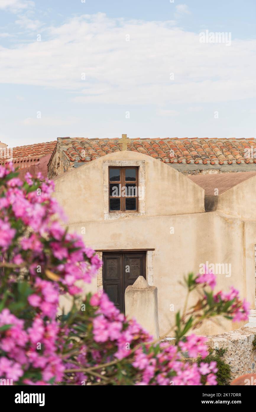 A vertical shot of an old glass window on a building wall with pink ...