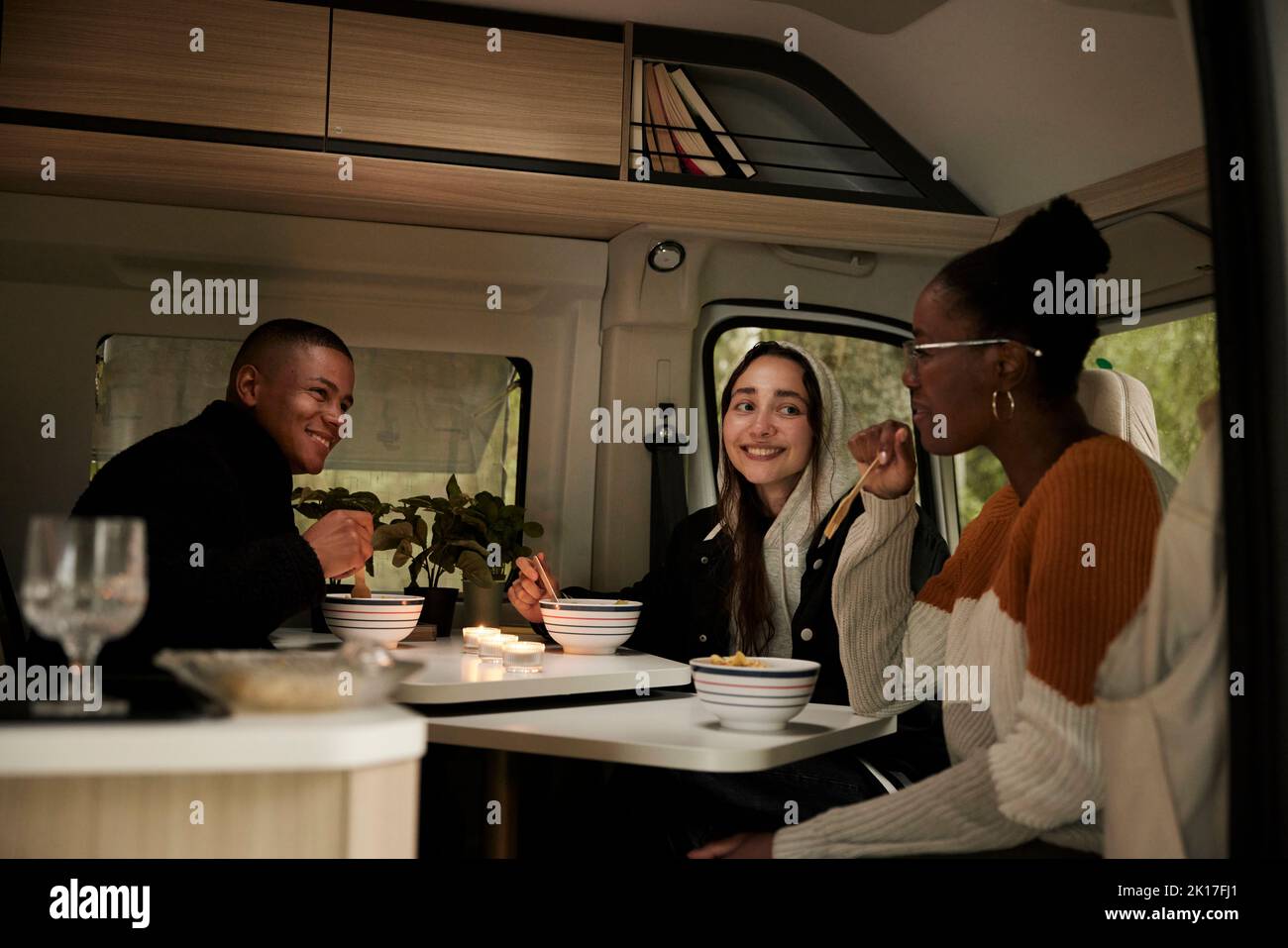 Friends having meal in camper van Stock Photo - Alamy