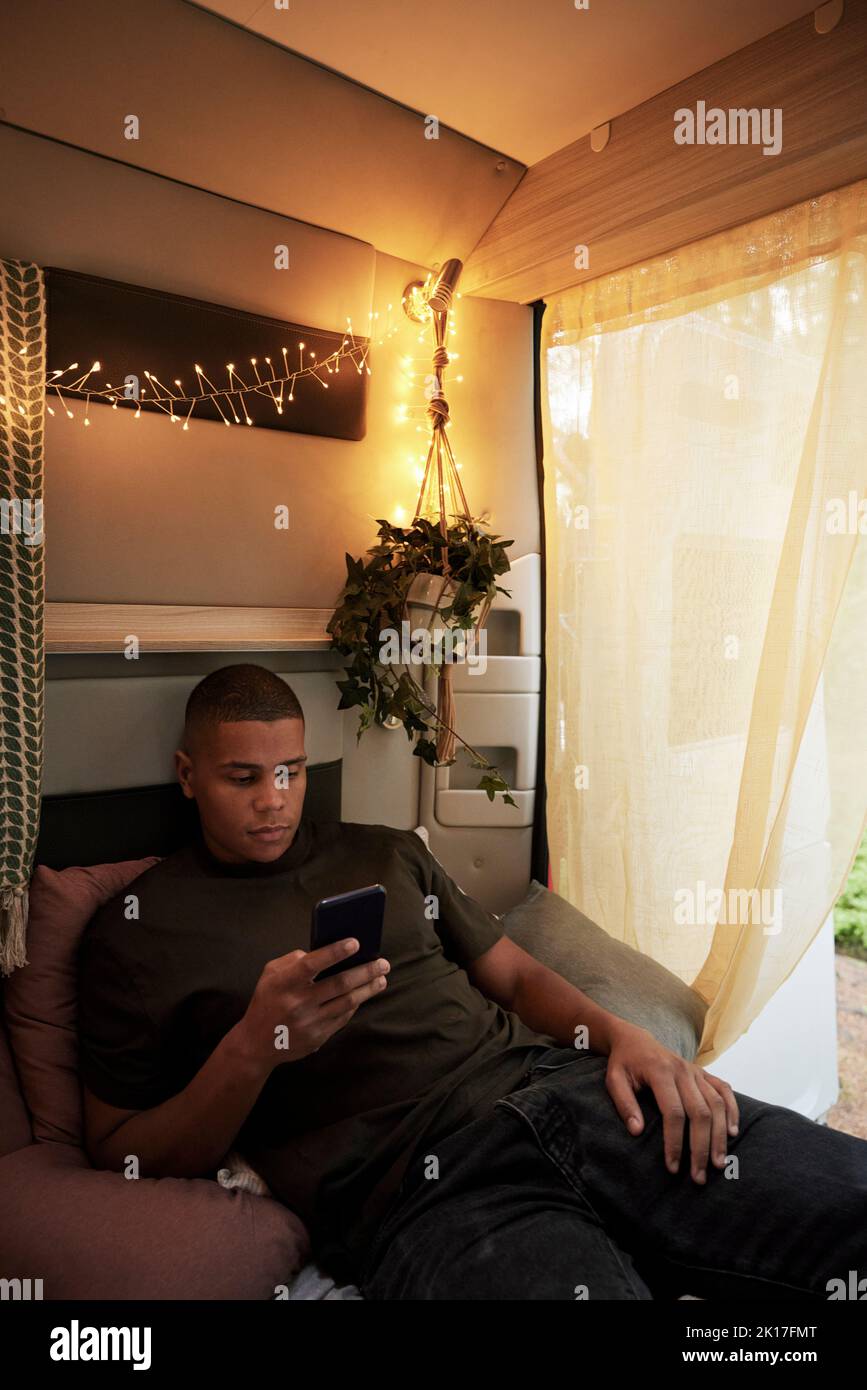 Man using phone in camper van Stock Photo - Alamy