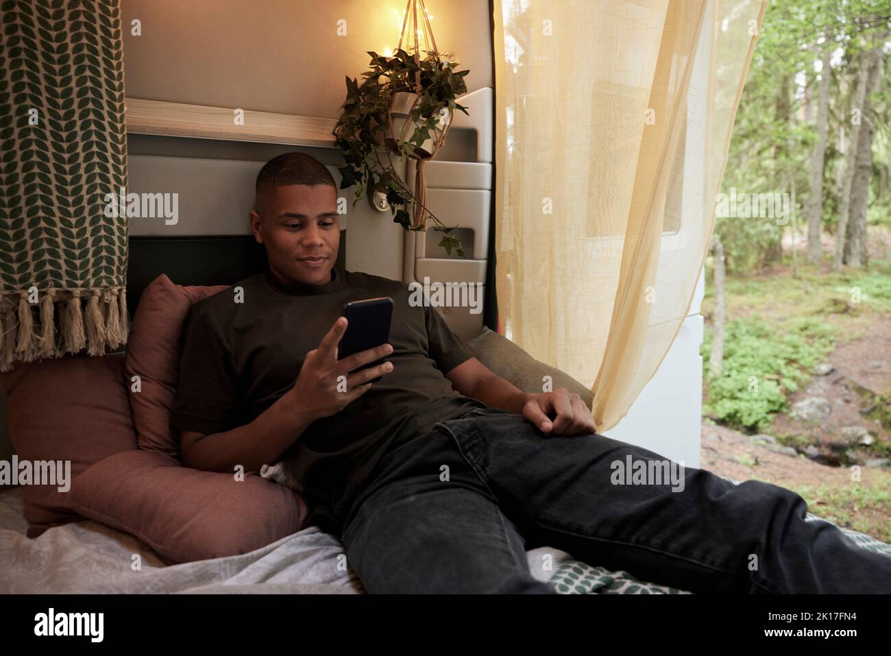 Man using phone in camper van Stock Photo - Alamy