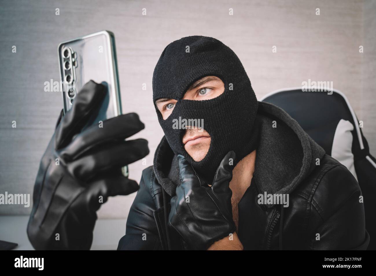 Young adult in black clothes with hidden face. Ill-intended fraudster ...