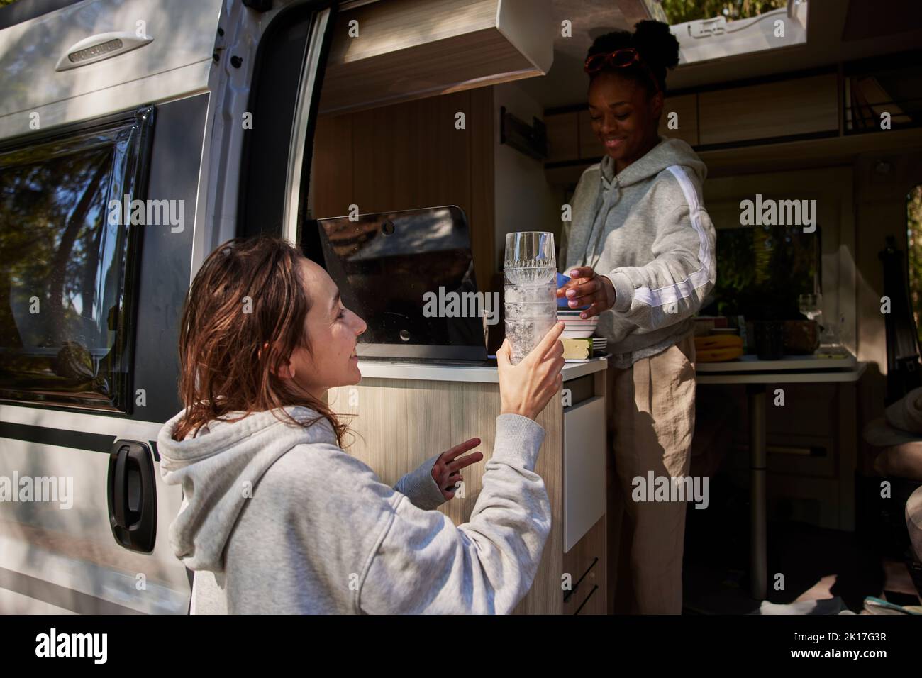 Women in camper van cleaning dishes Stock Photo - Alamy