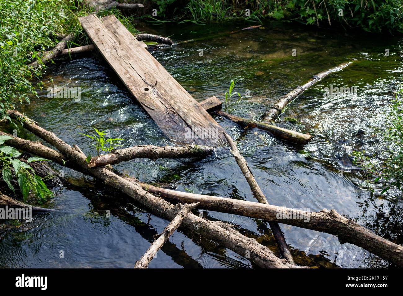 Throwed branches and boards for crossing the stream, a makeshift bridge ...