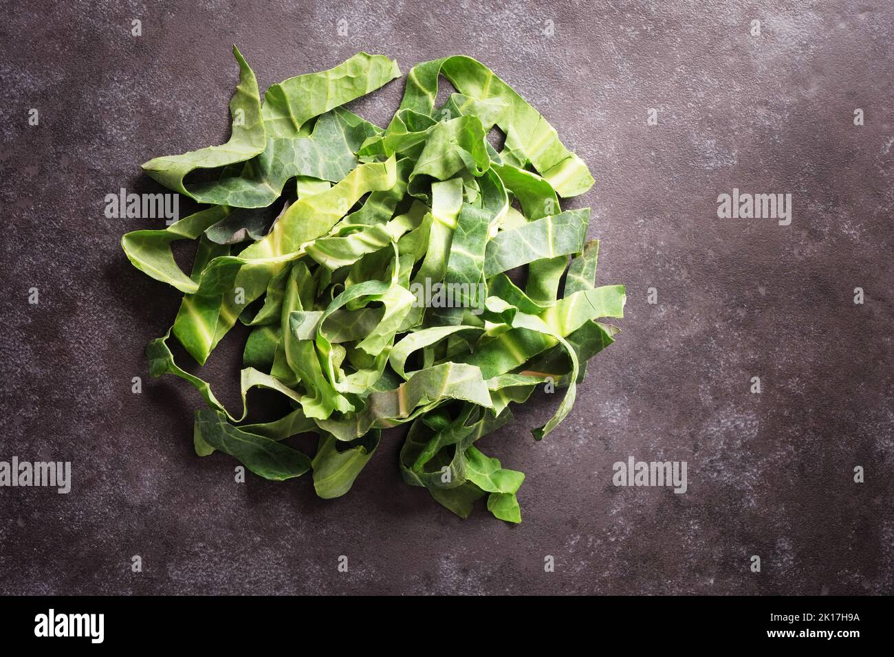 Pile of sliced green vegetables shot from above on dark stone ...