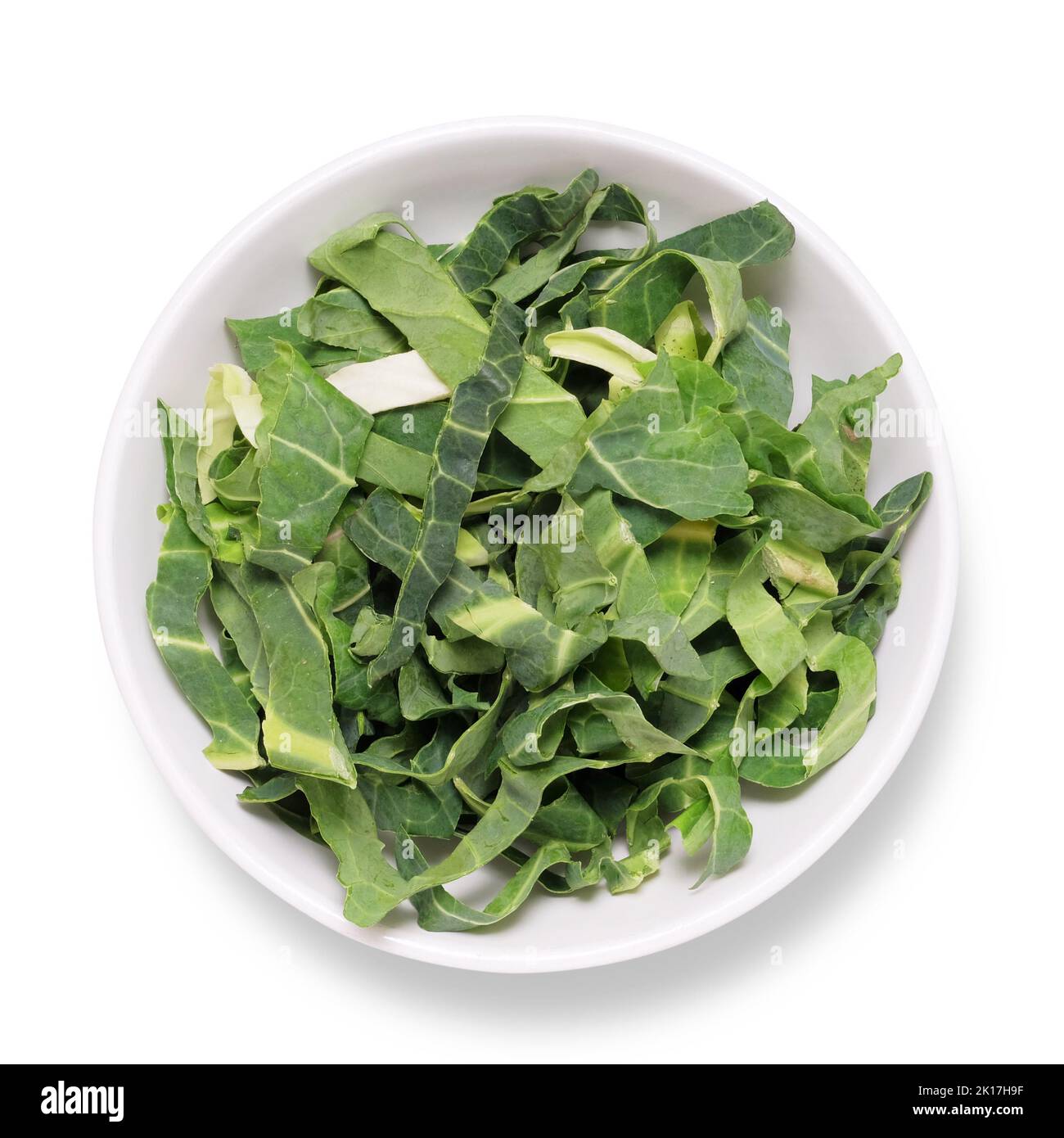 Sliced green vegetables in white bowl shot from above isolated on white ...