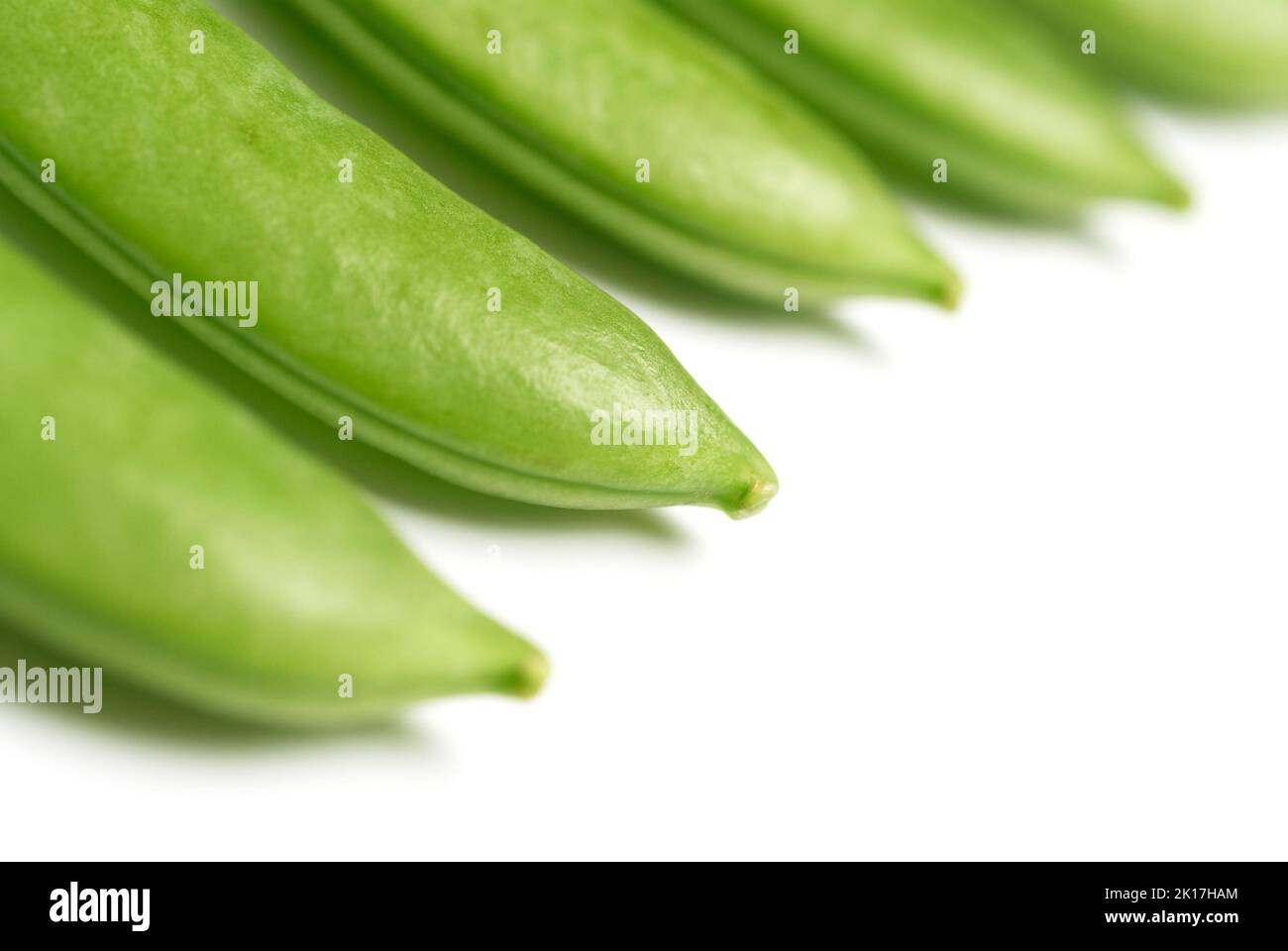 Several sugar snap peas on white background Stock Photo - Alamy