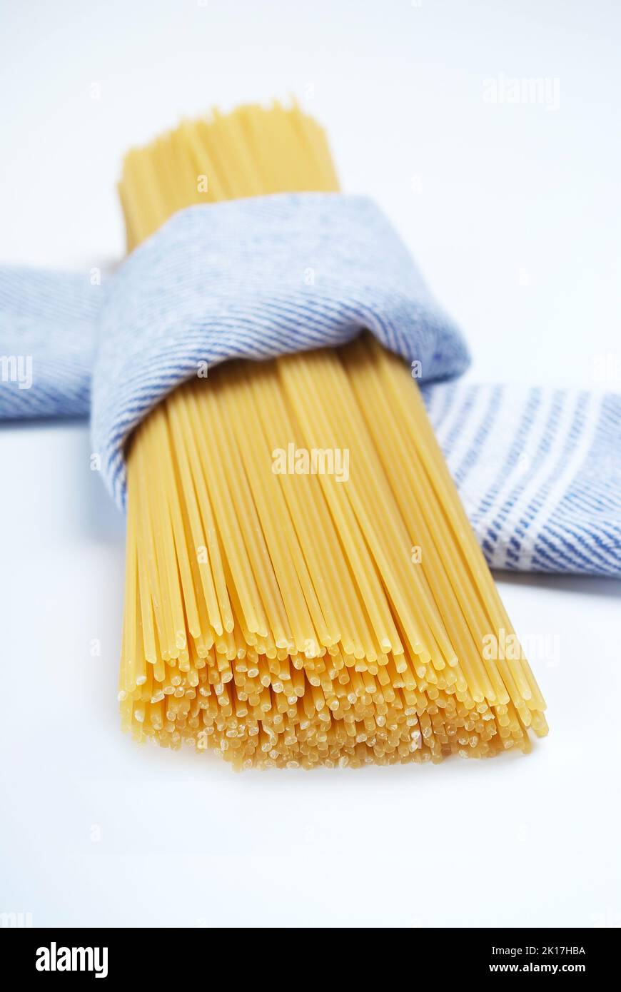 Bunch of raw spaghetti wrapped in a cloth vertical with copy space ...