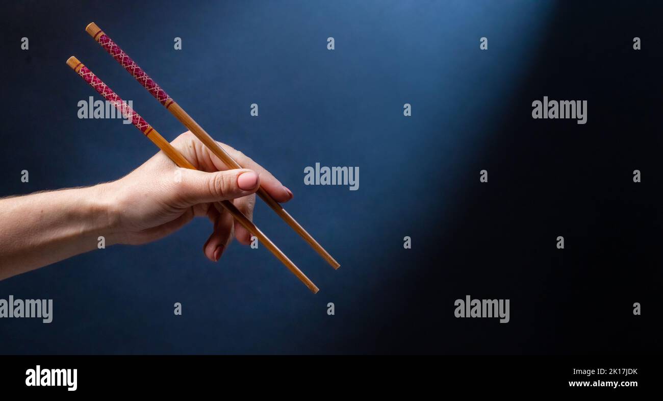Hand holding chopstick Stock Photo - Alamy