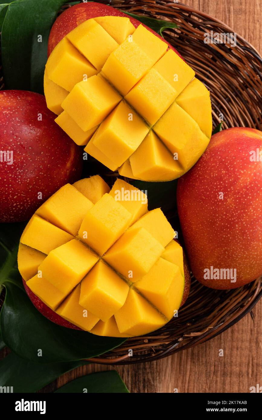 Top view of fresh ripe mango fruit with leaves over dark wooden table ...