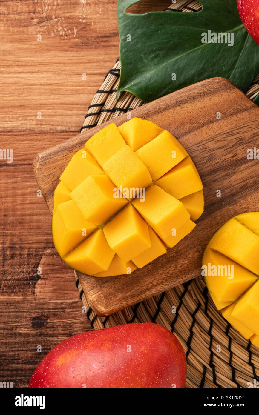 Top view of fresh ripe mango fruit with leaves over dark wooden table ...