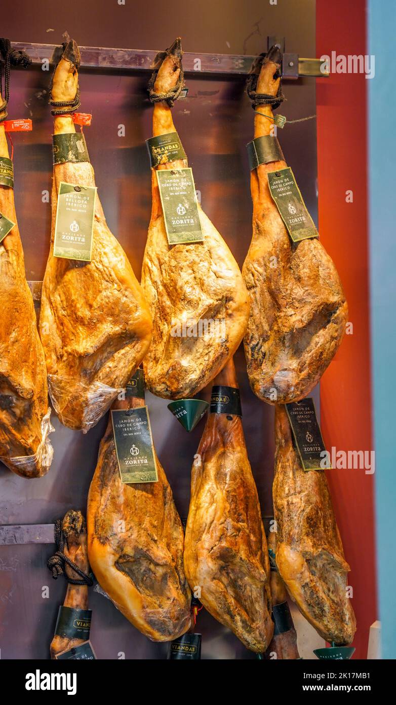 A display of different brands of Spanish Ham, Jamon Serrano in a shop ...