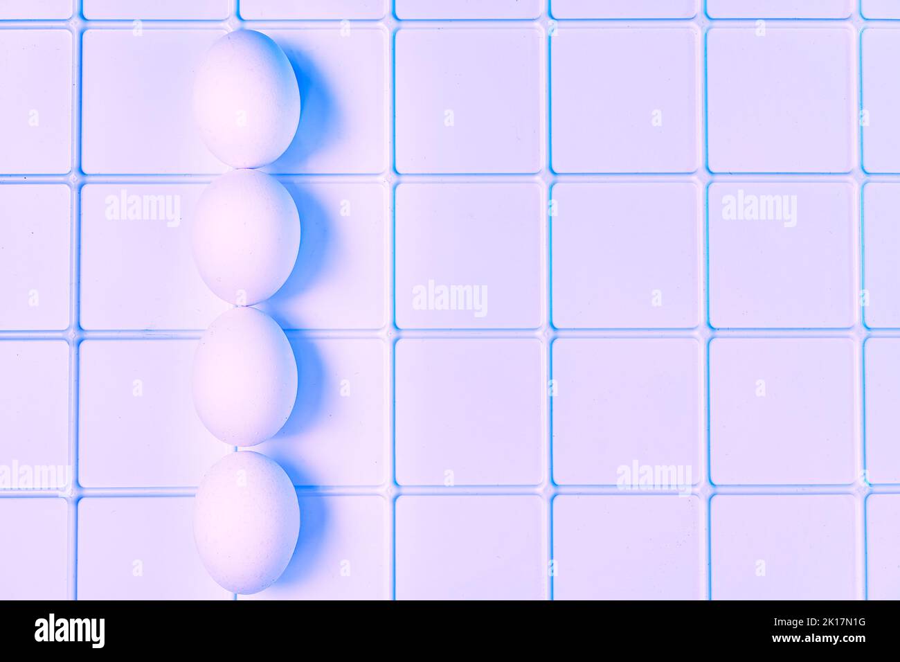 Four chicken bird eggs on a plastic blue purple checkered surface Stock ...