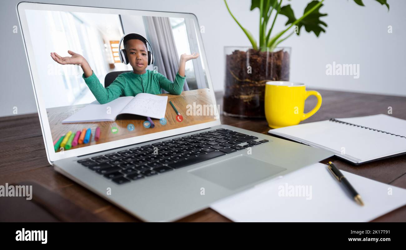 African american pupil having online lesson on screen of laptop on desk ...