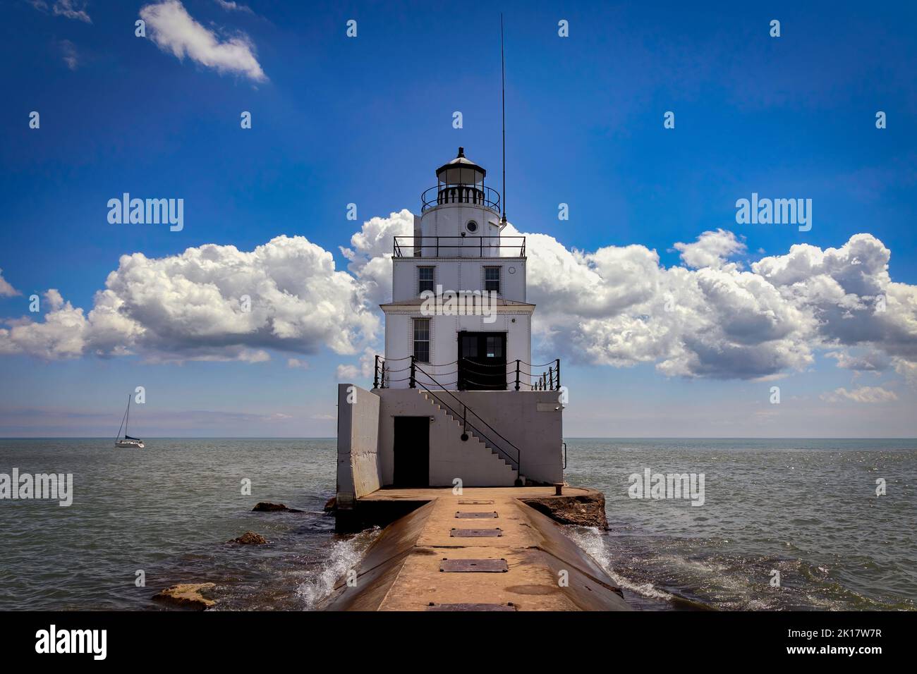 The north pier lighthouse, built in 1918, with a sailboat exiting the ...