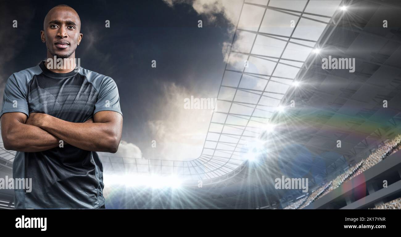 Composition of male rugby player with arms crossed over sports stadium ...