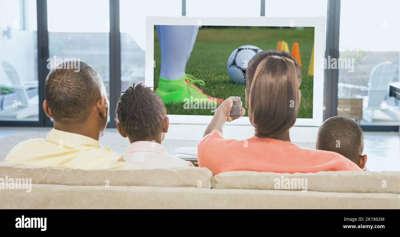 Composition of rear view of family of sports fans sitting on couch ...