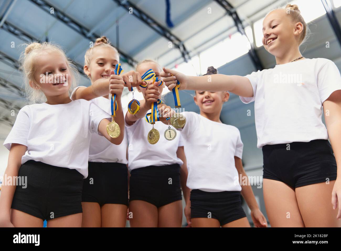Happy little girls, female gymnastics athletes showing their medals at ...