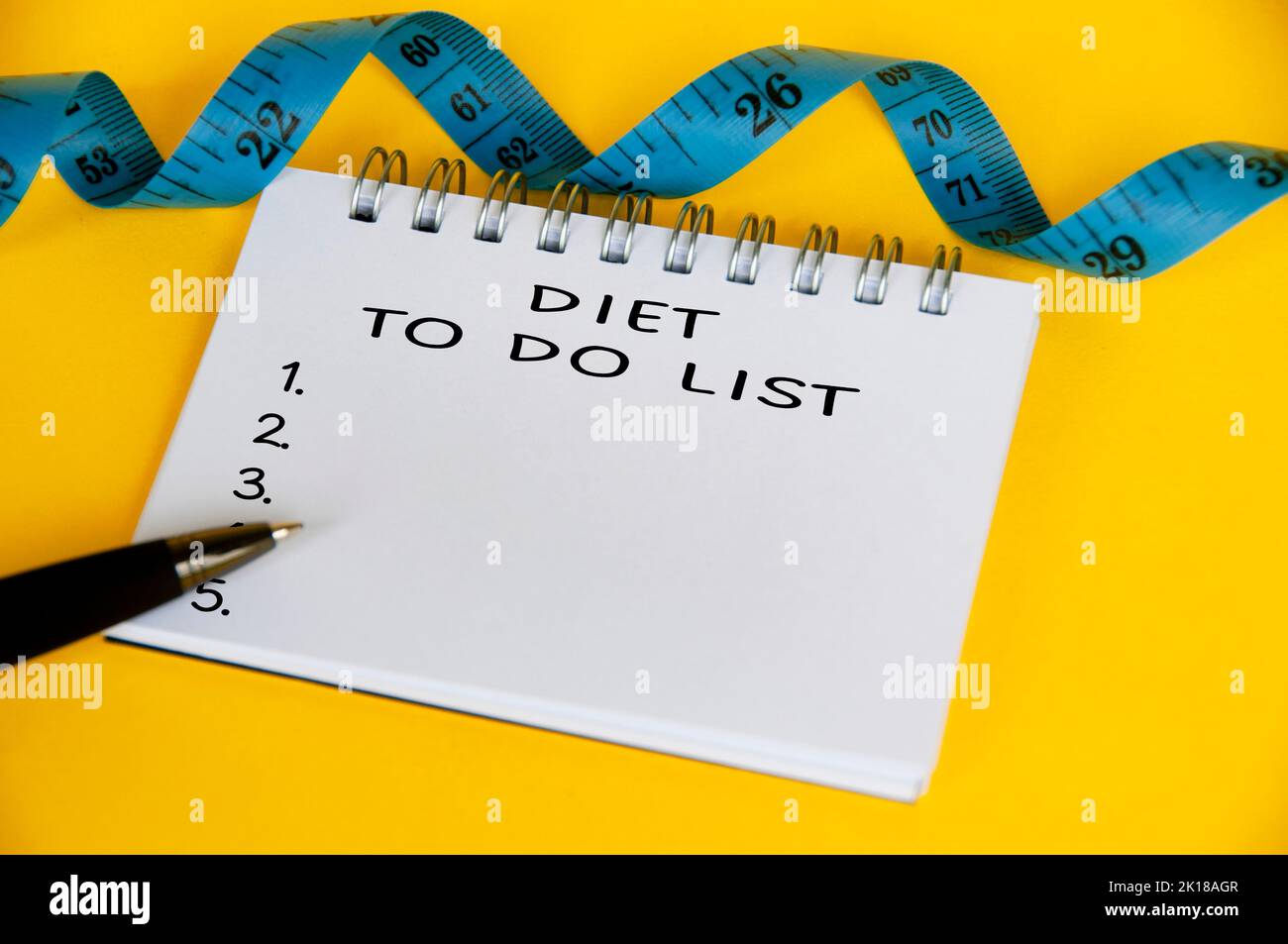Diet to do list text on white notepad with blue measuring tape on ...