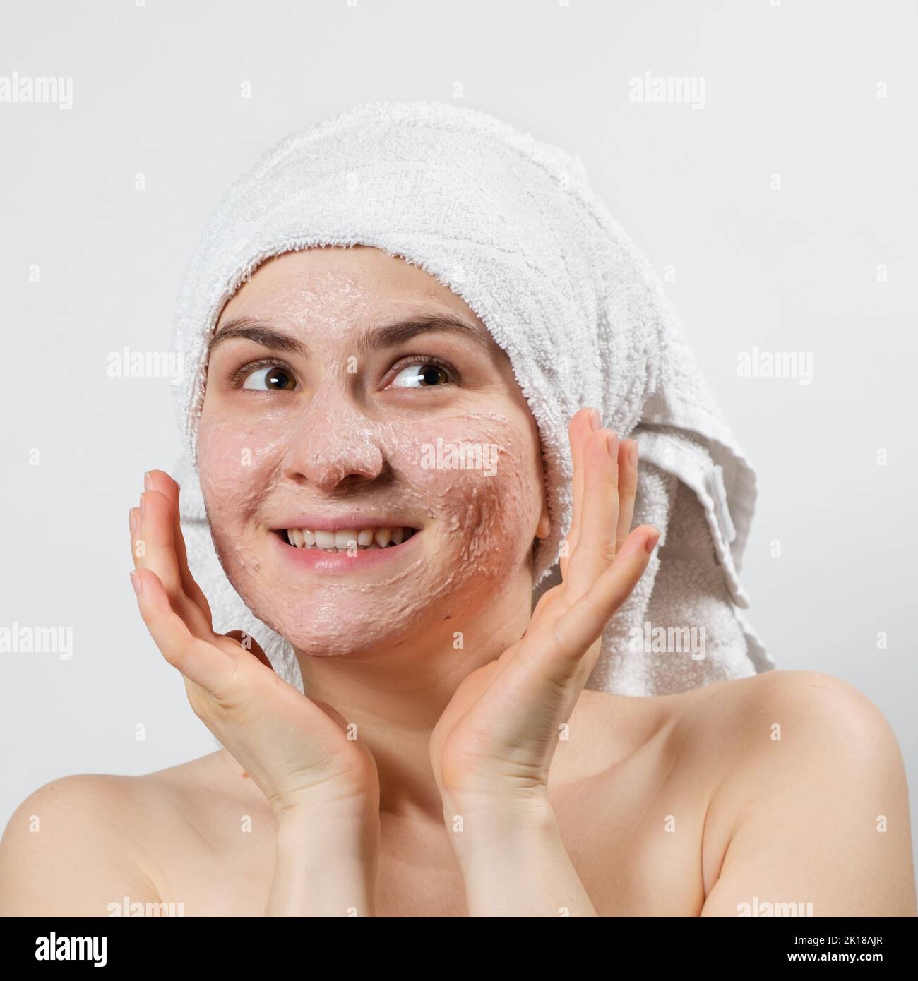 A beautiful young woman applied a scrub or mask to her face, facial ...