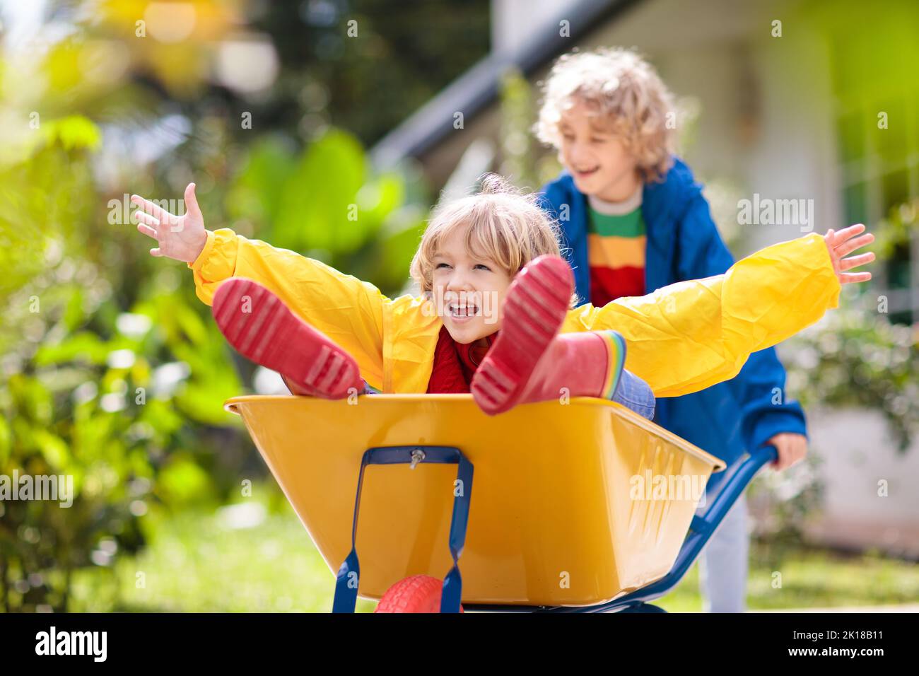 Kids in wheelbarrow on pumpkin patch. Autumn outdoor fun for children ...