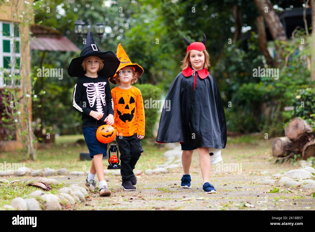 Child in Halloween costume. Kids trick or treat on suburban street ...