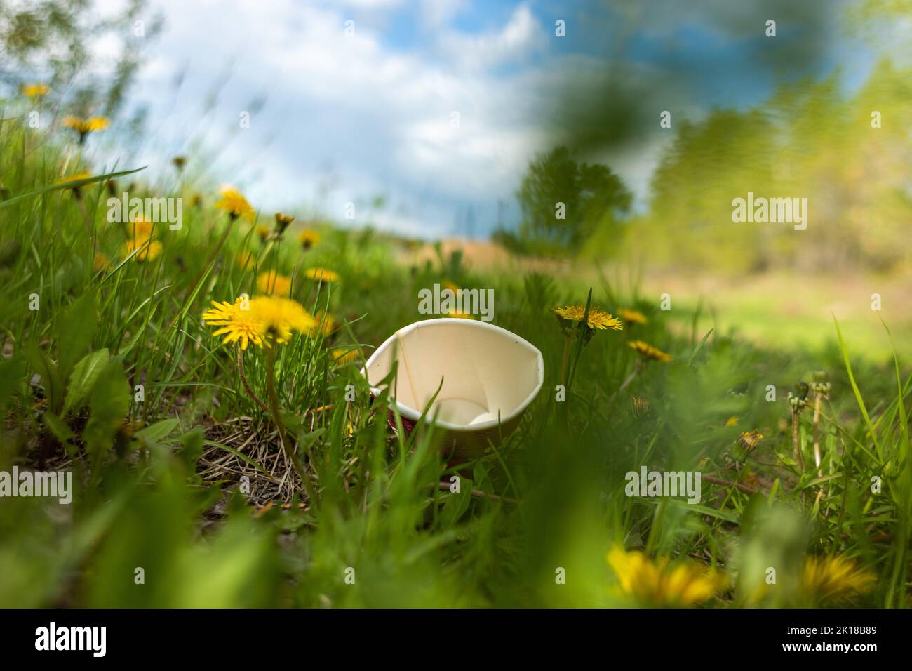 Abandoned garbage plastic and glass waste in nature among the grass ...