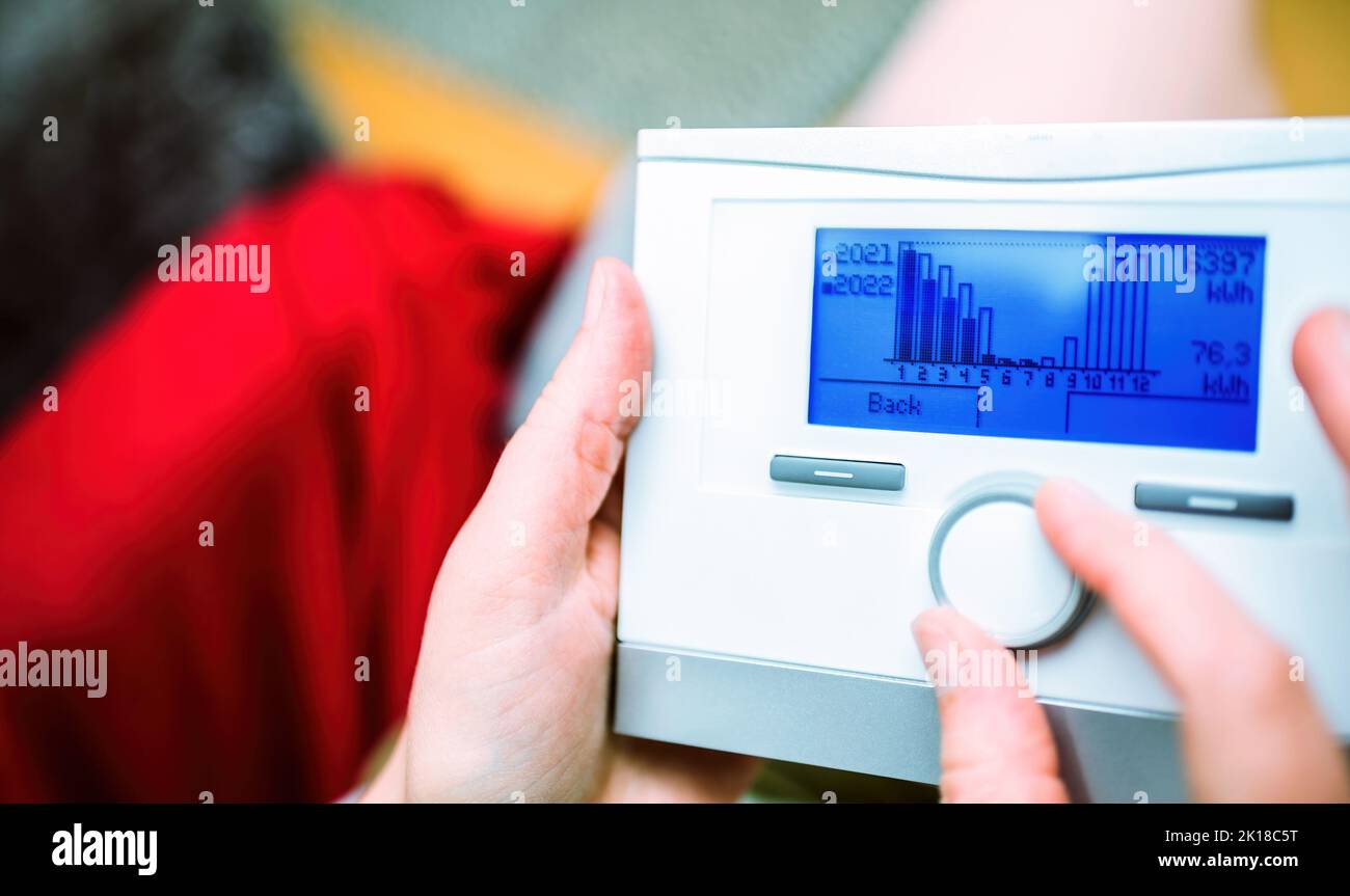Woman turning knob on new weather compensating programmable room ...