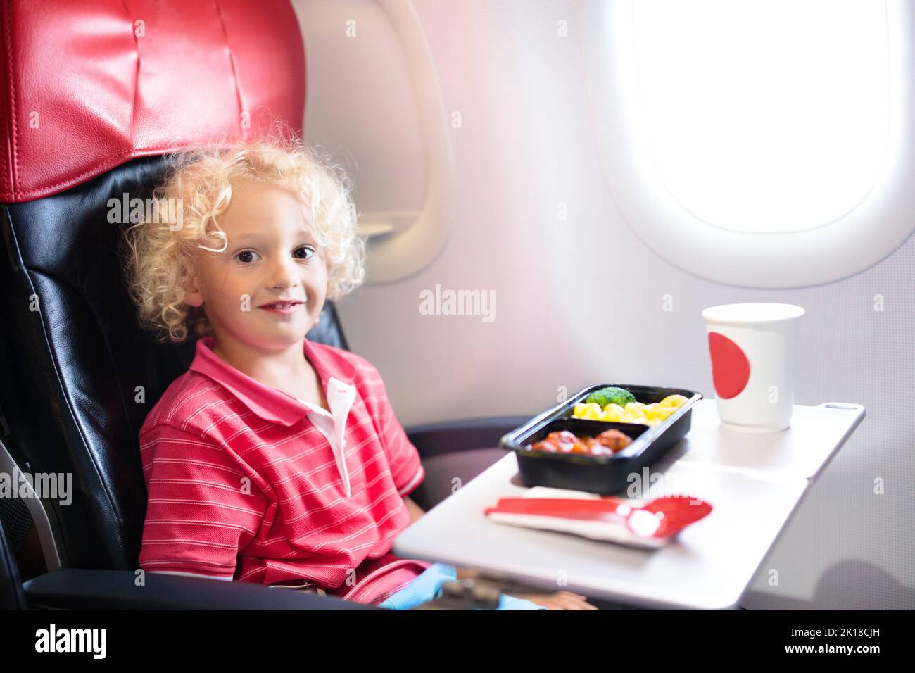 Child in airplane window seat. Kids flight meal. Children fly. Special ...