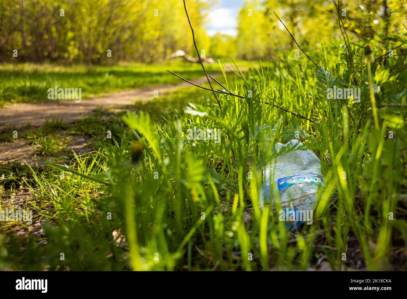 Abandoned garbage plastic and glass waste in nature among the grass ...