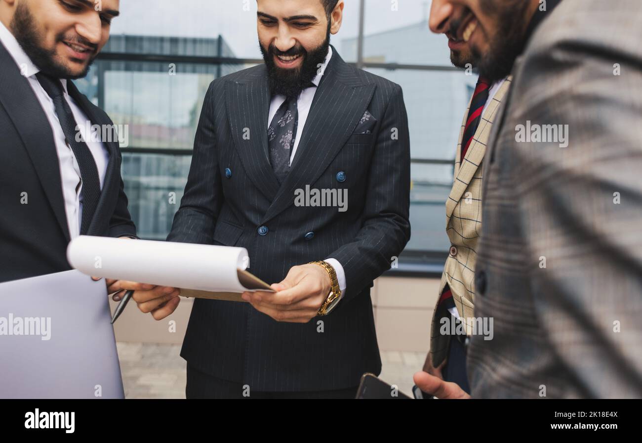 Business people outdoor meeting. Men in jackets discuss working moments ...