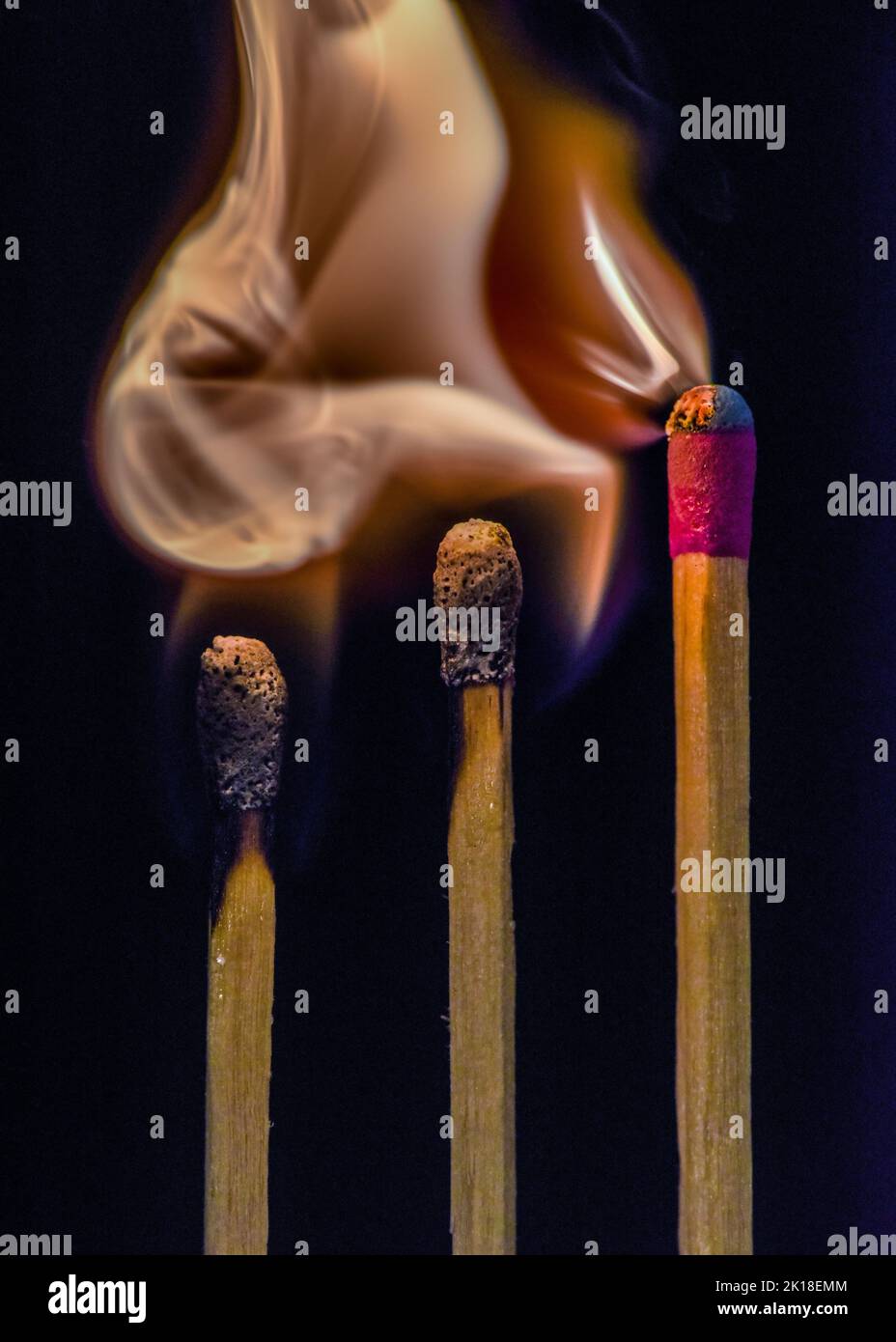 Three matches, one catching fire from the other. Concept: teamwork ...