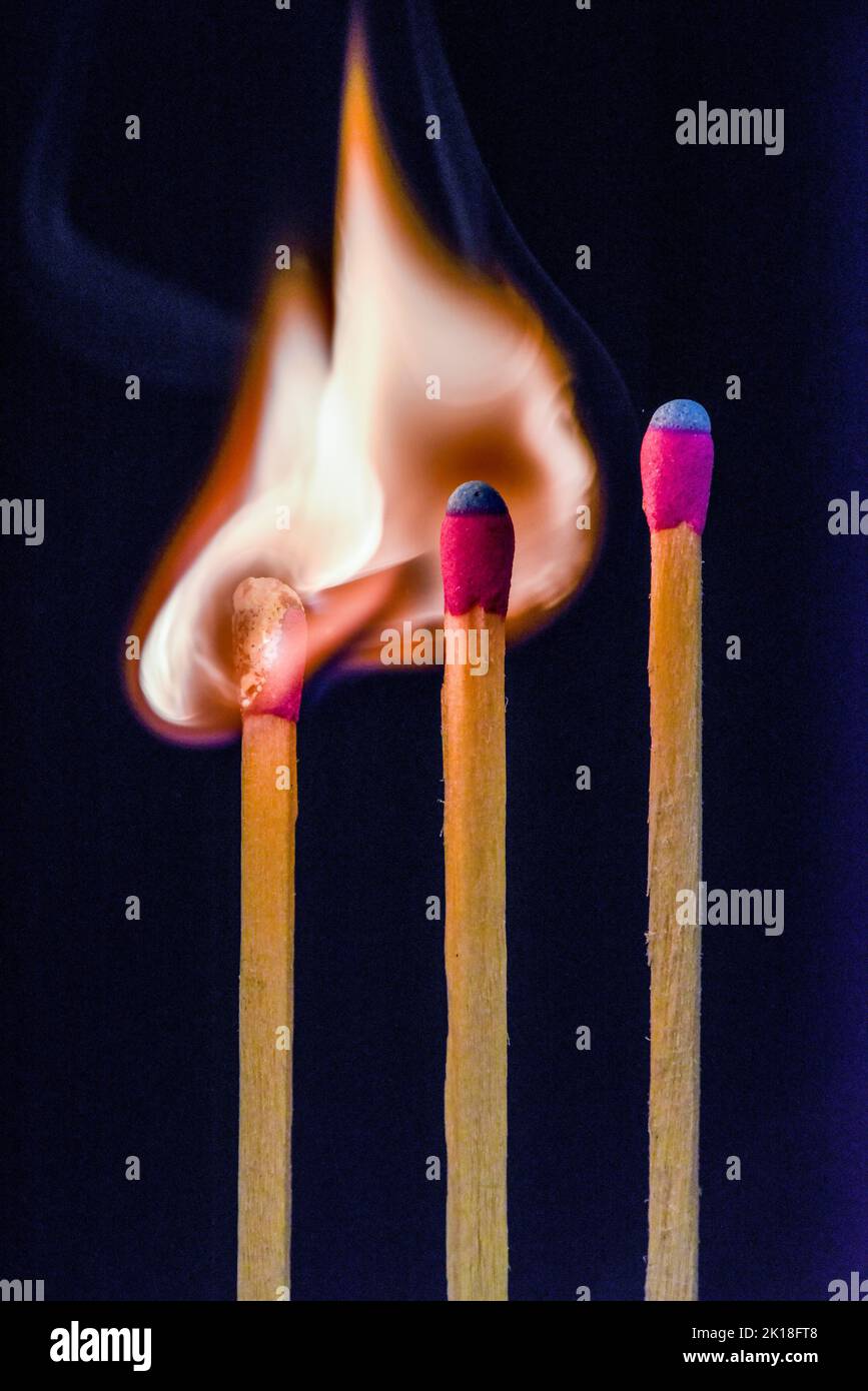 Three matches, one catching fire from the other. Concept: teamwork ...