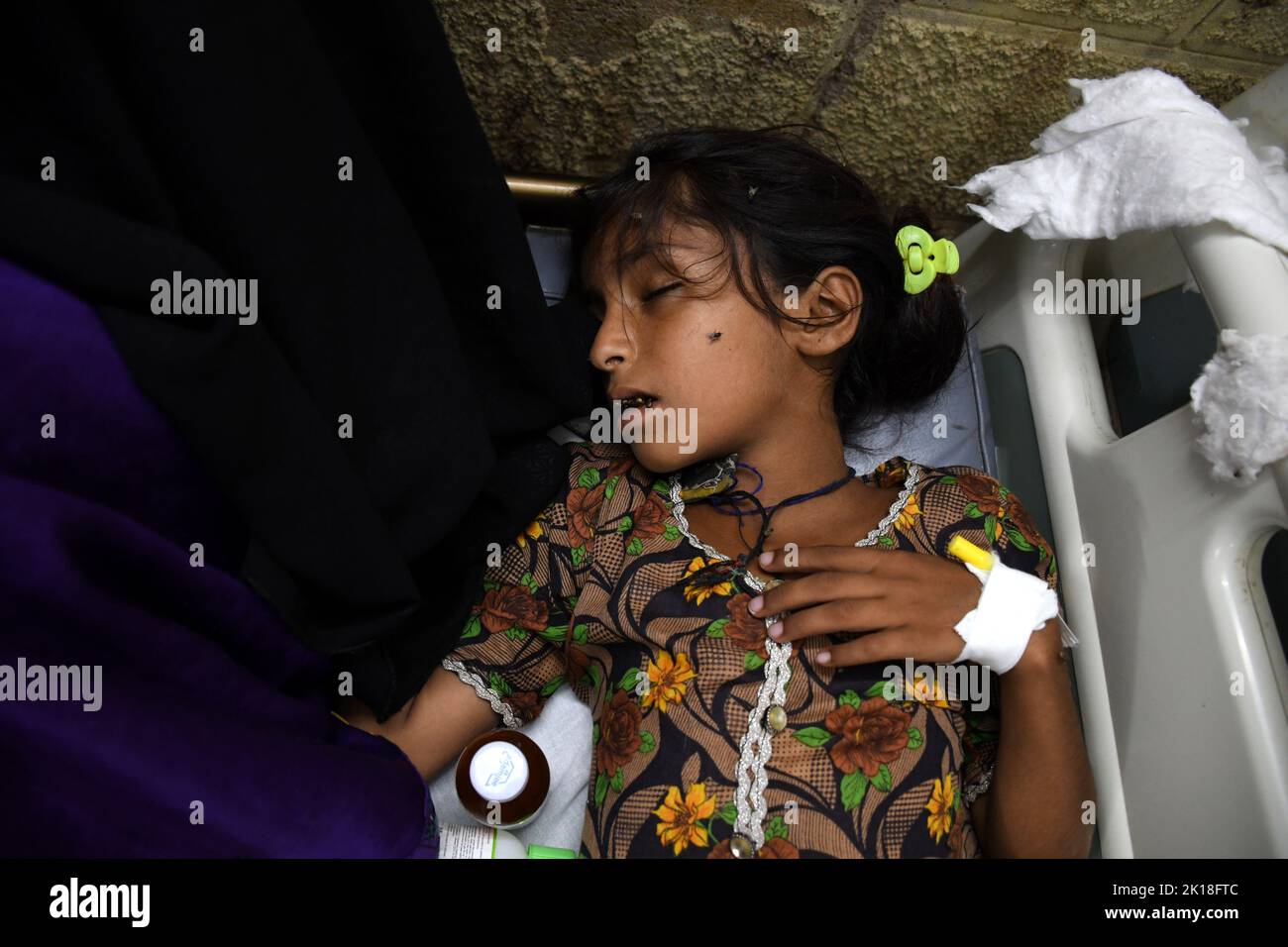 A woman, who became flood victim, takes care of her ailing baby at a ...