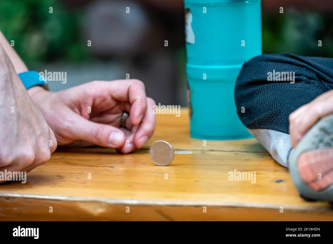 Two people playing a game with a spinning coin in order to pass time ...
