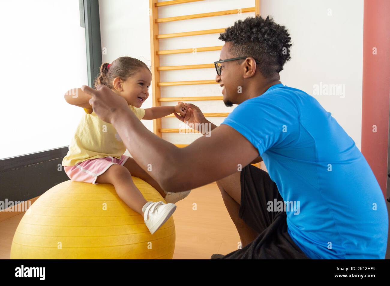 Black father and daughter exercising with fit ball Stock Photo - Alamy