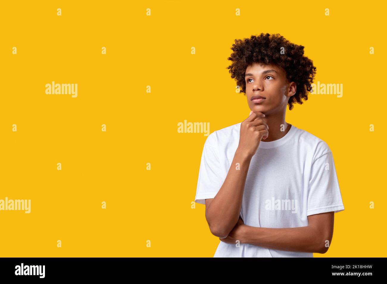 Create idea. Social tolerance. Pensive black teen boy with hand on chin ...