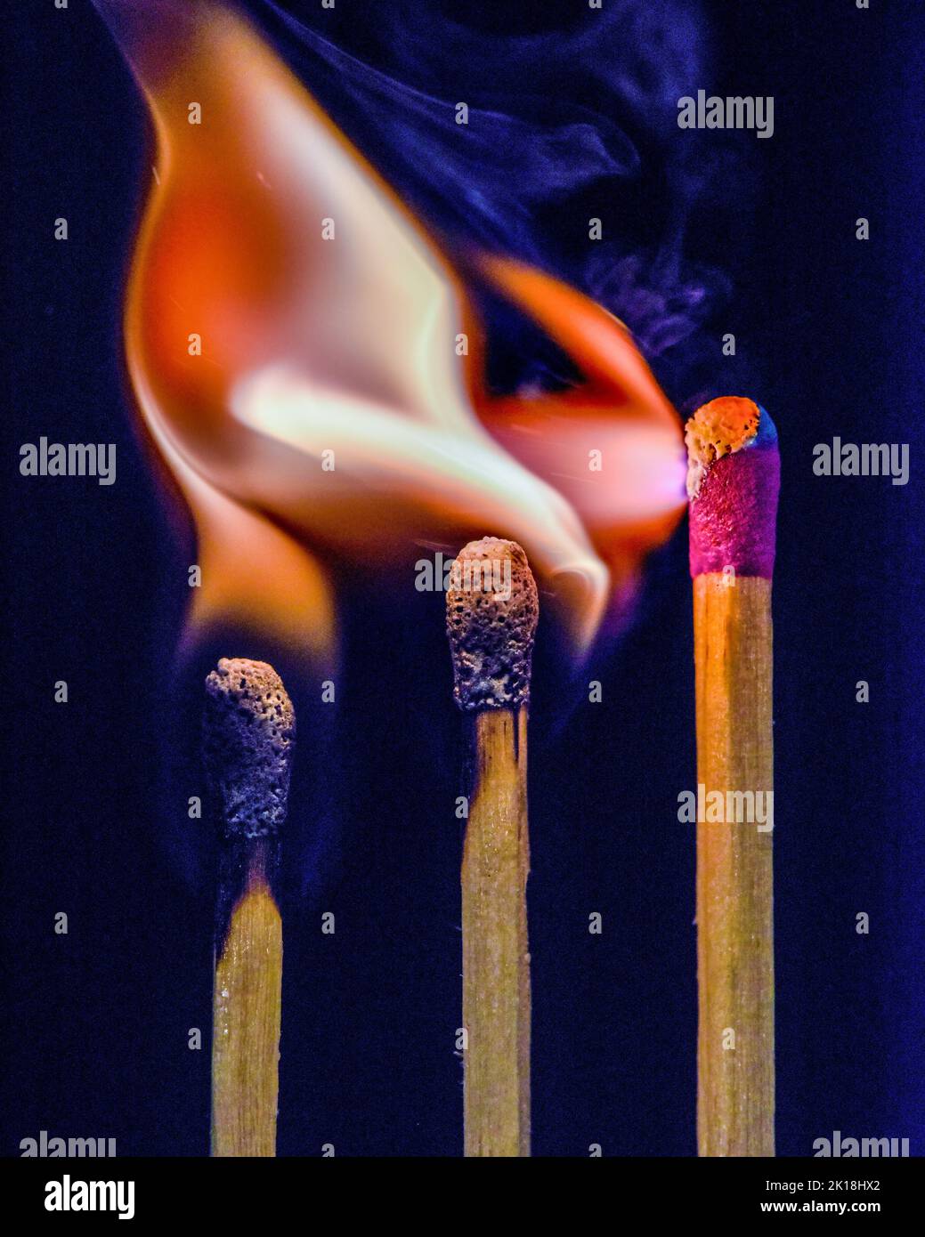 Three matches, one catching fire from the other. Concept: teamwork ...