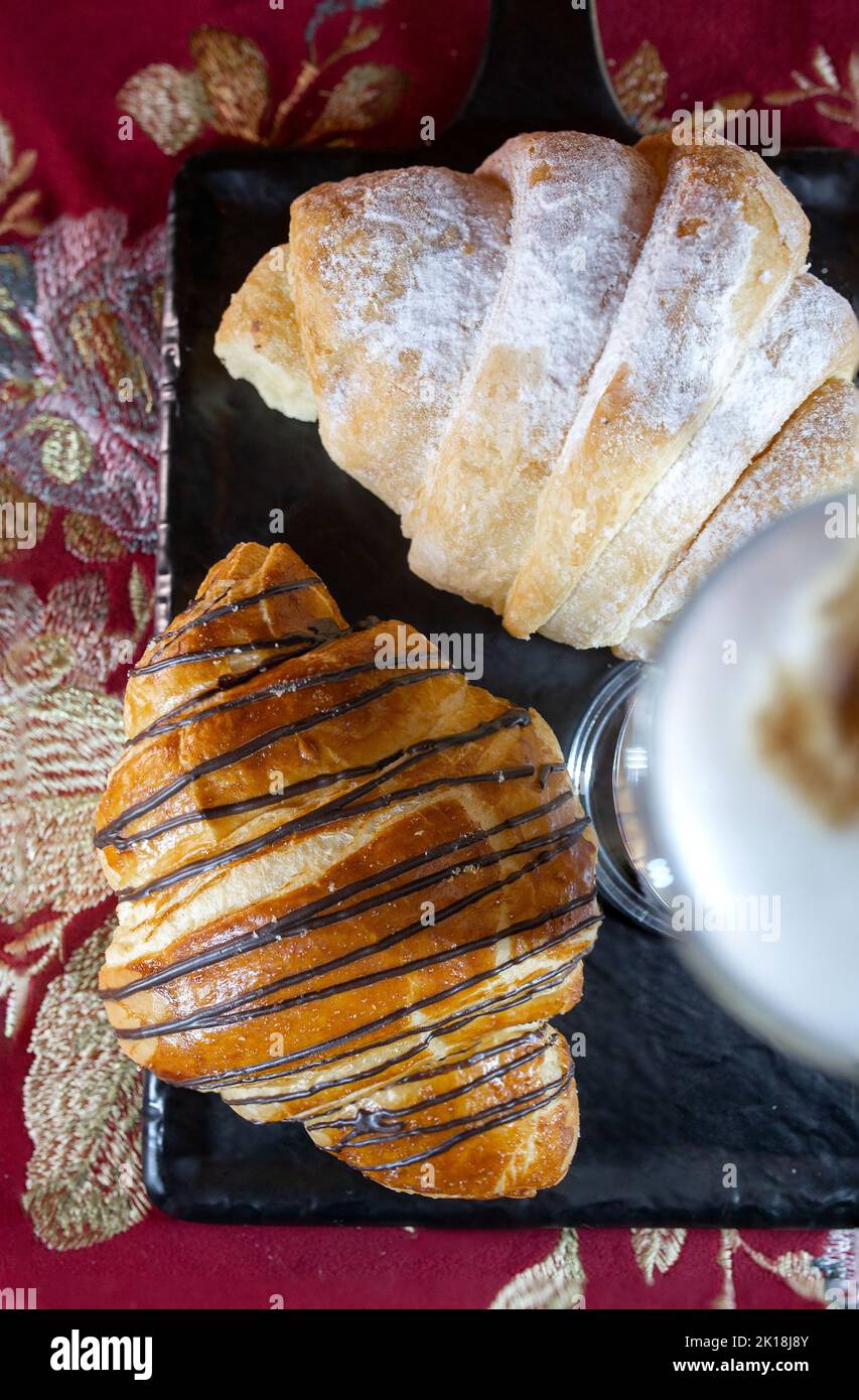 different croissants on a black plate with coffee top view Stock Photo ...