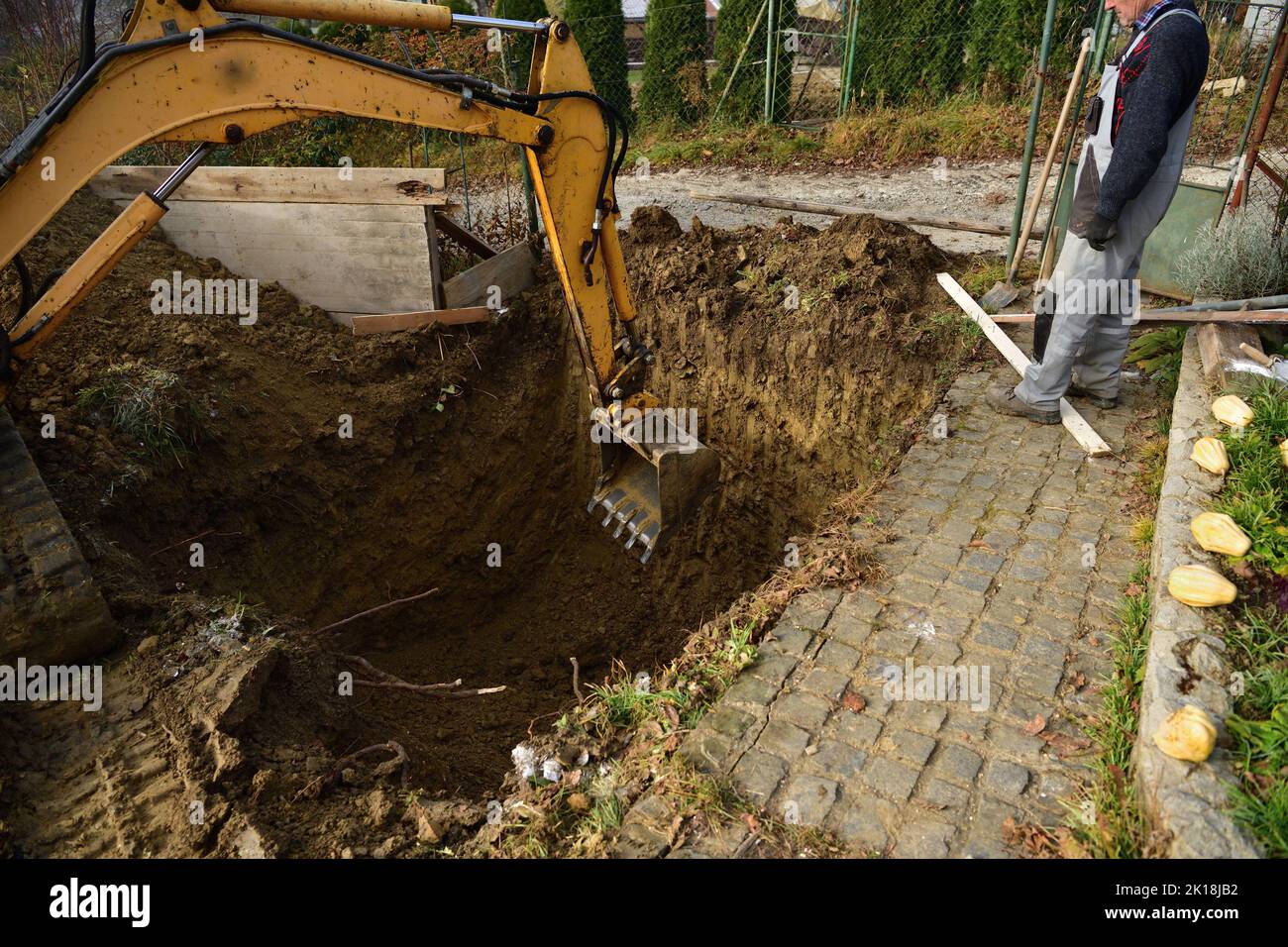 A combination of heavy excavator equipment and human masonry work ...