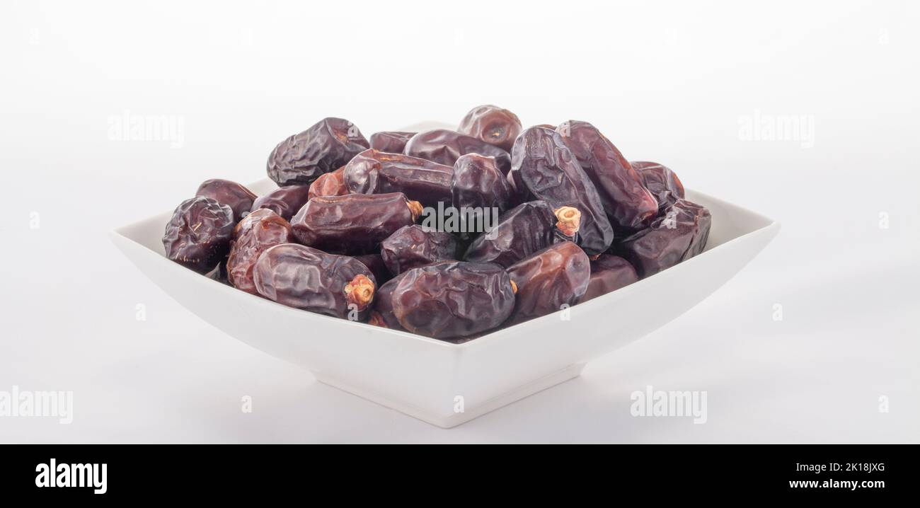 A group of stuffed sukkari dates with nuts and herbs isolated on white ...
