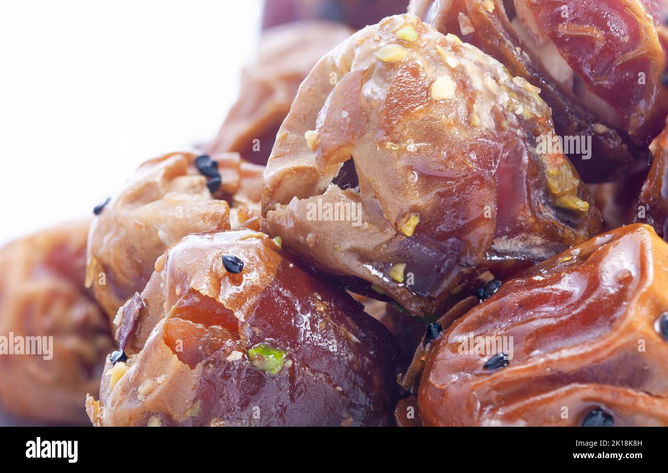 A group of stuffed sukkari dates with nuts and herbs isolated on white ...