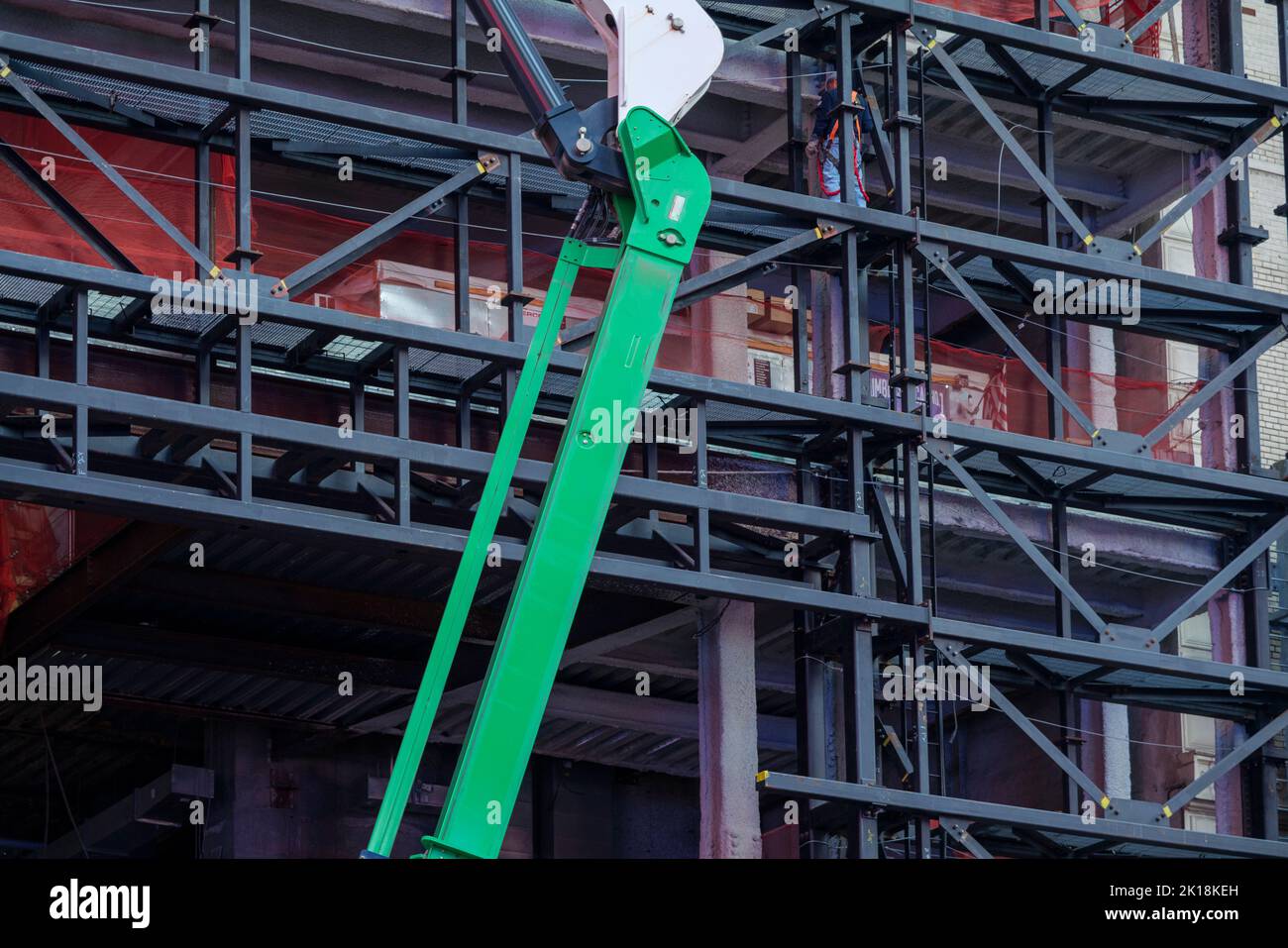 Boom lift stands against scaffolding around building construction Stock ...