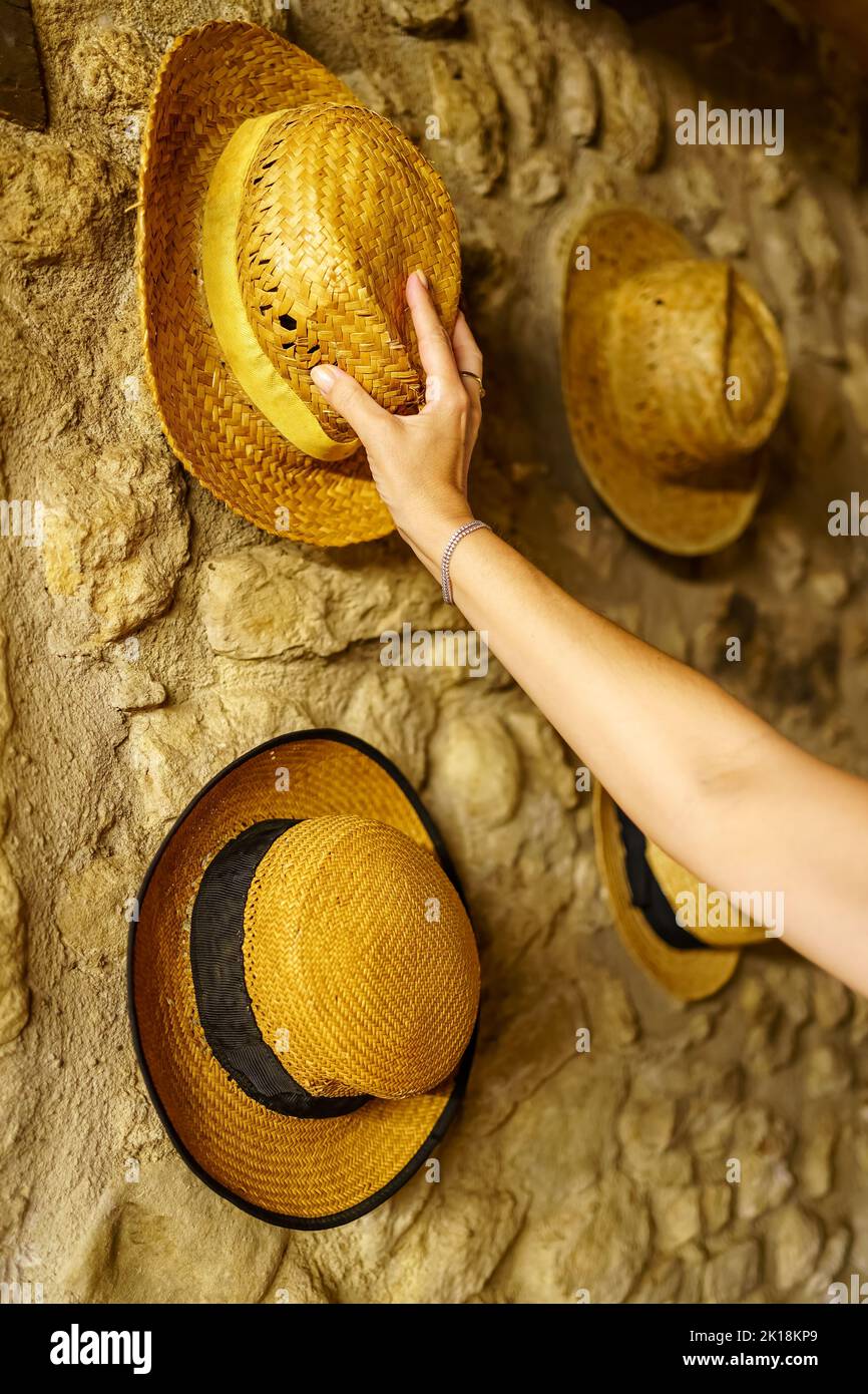 Straw hats hanging on the wall of an old retro-style house reminiscent ...