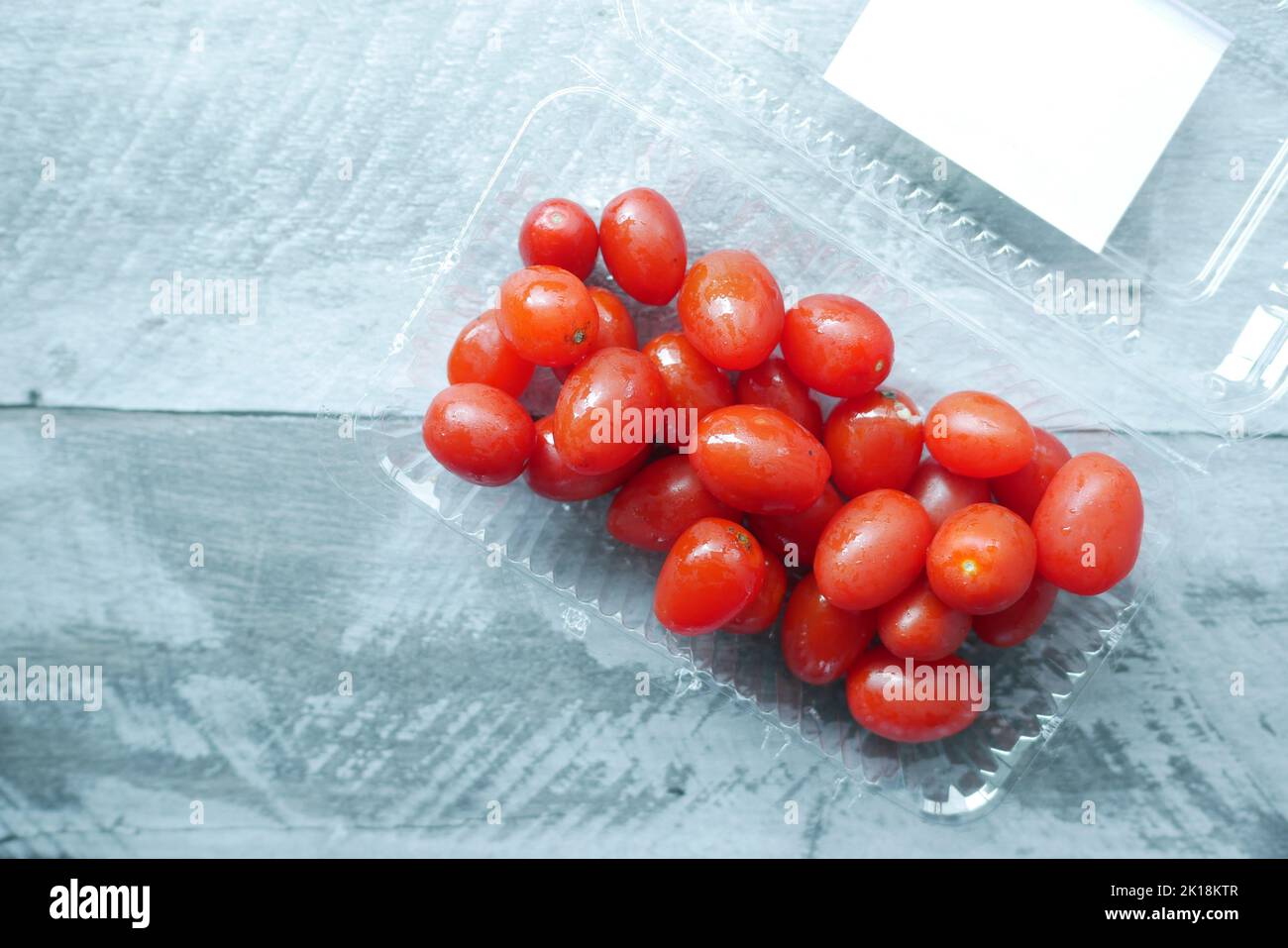 red color cherry tomato on plastic container on table Stock Photo - Alamy
