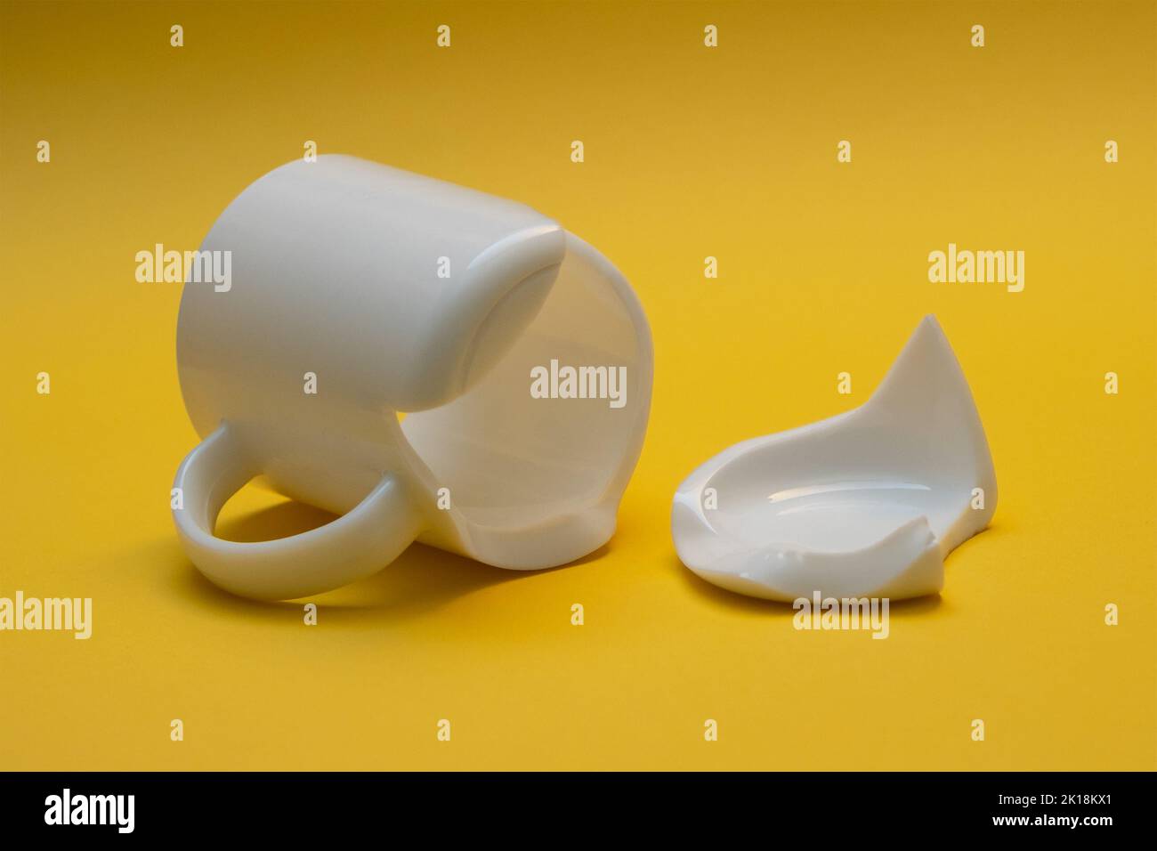 Splinters of the broken tea mug on a yellow background Stock Photo - Alamy